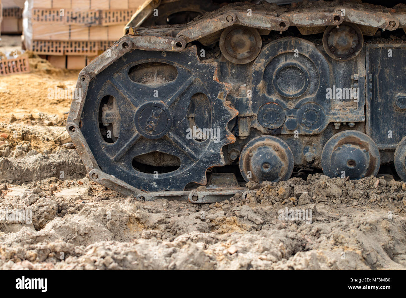 Tracked excavator work construction road .Close up of steel wheels ...