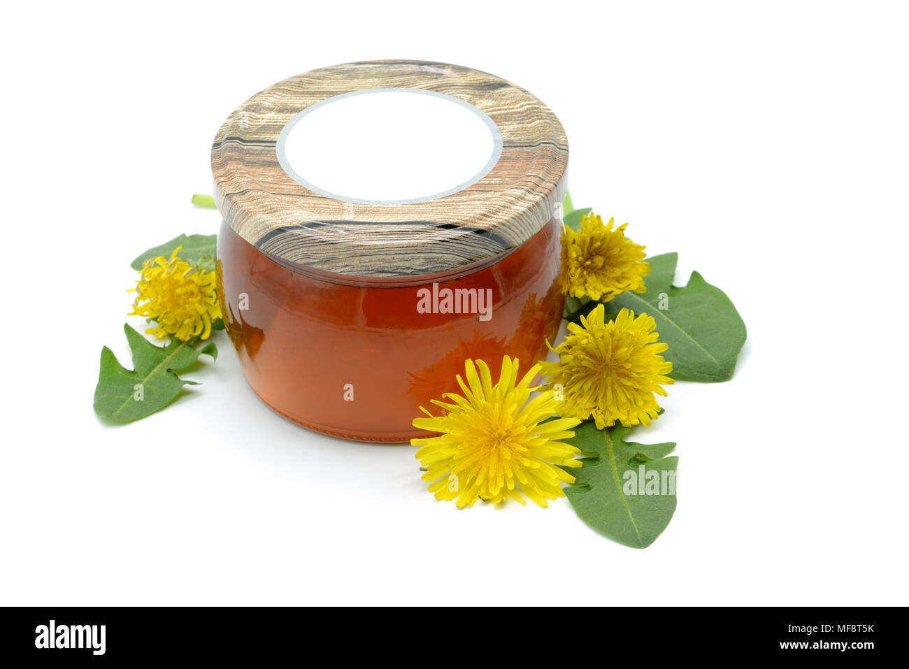 homemade Dandelion honey with honey glass and flower heads of danelion ...