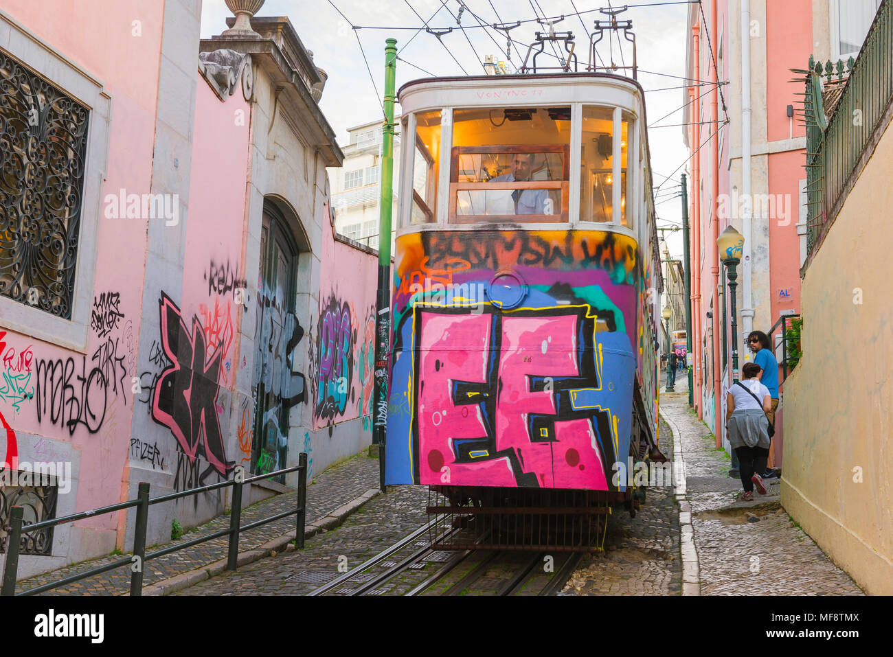 Lisbon Portugal, view of a colorful graffitied tram car descending the ...
