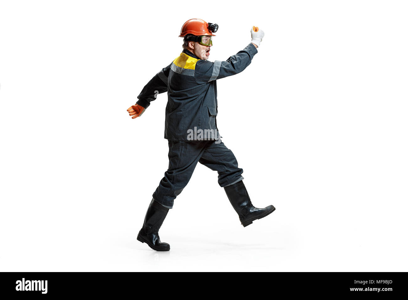 The studio shot of senior bearded male miner standing at the camera on ...