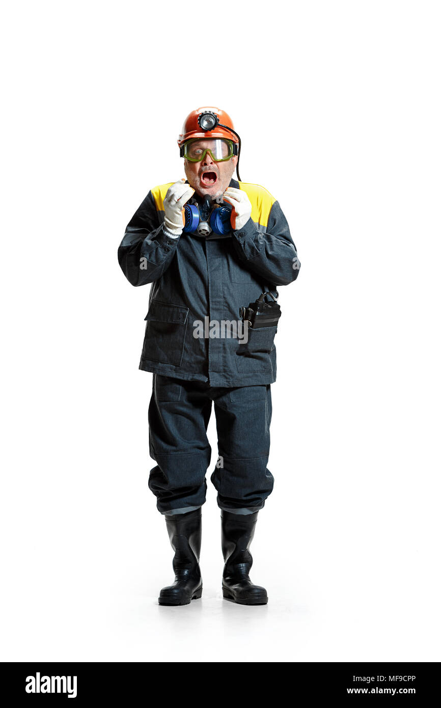 The studio shot of senior bearded male miner standing at the camera on ...