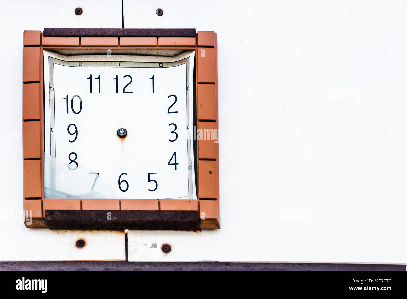 rusty, old broken clock, without arrows on a light wall with space for ...
