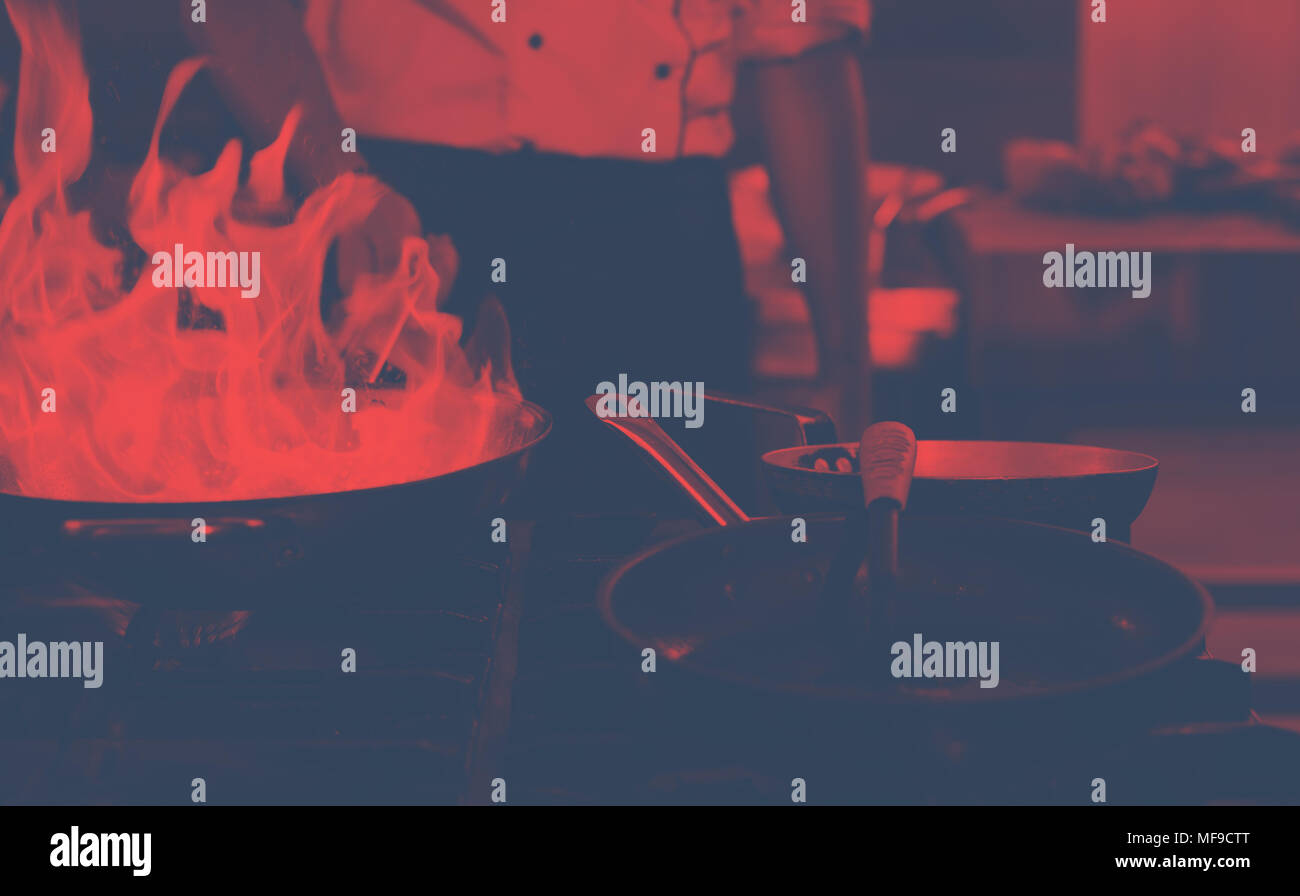 Chef cooking and doing flambe on food in restaurant kitchen Stock Photo ...