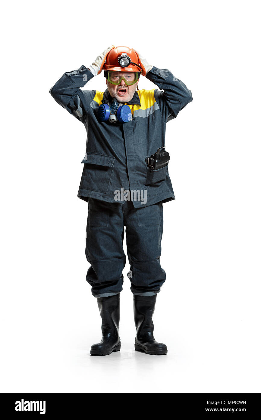 The studio shot of senior bearded male miner standing at the camera on ...