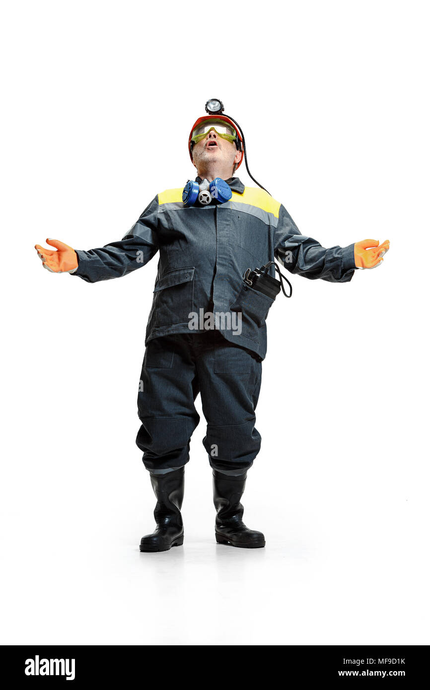 The studio shot of senior bearded male miner standing at the camera on ...