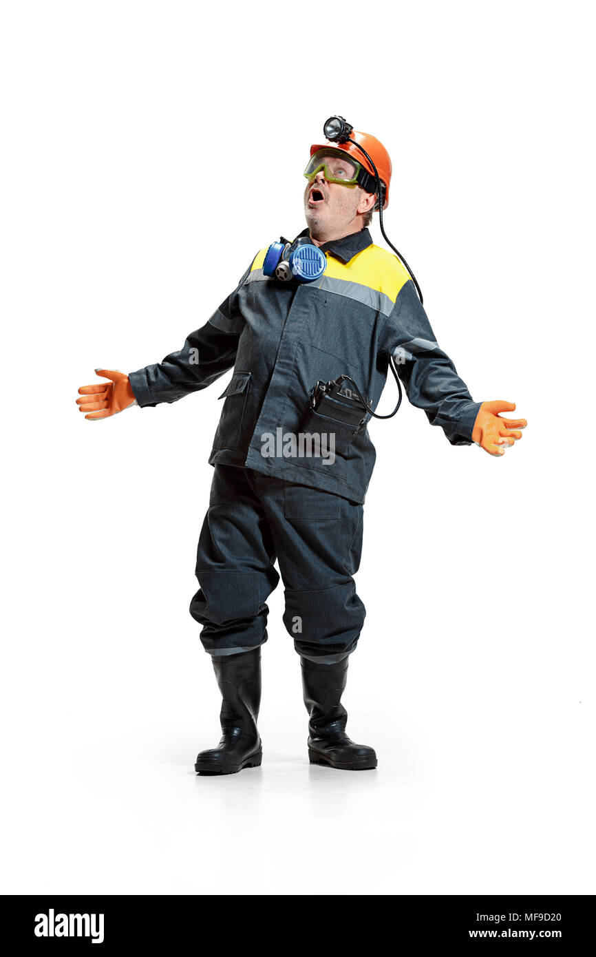 The studio shot of senior bearded male miner standing at the camera on ...