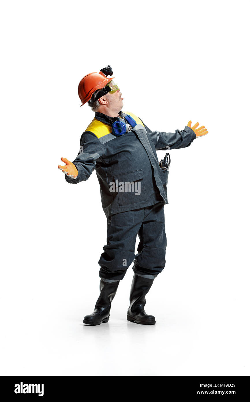 The studio shot of senior bearded male miner standing at the camera on ...