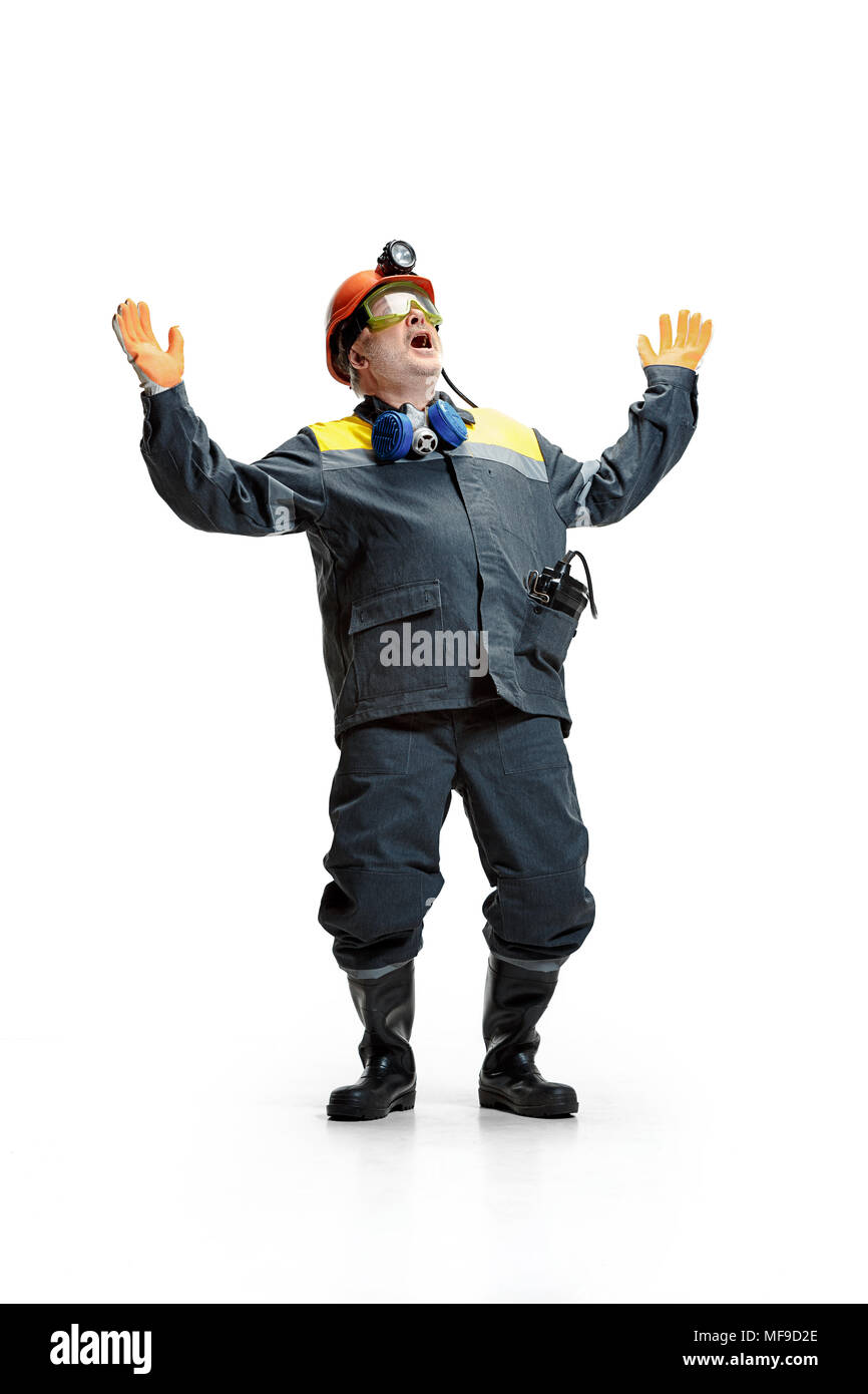 The studio shot of senior bearded male miner standing at the camera on ...