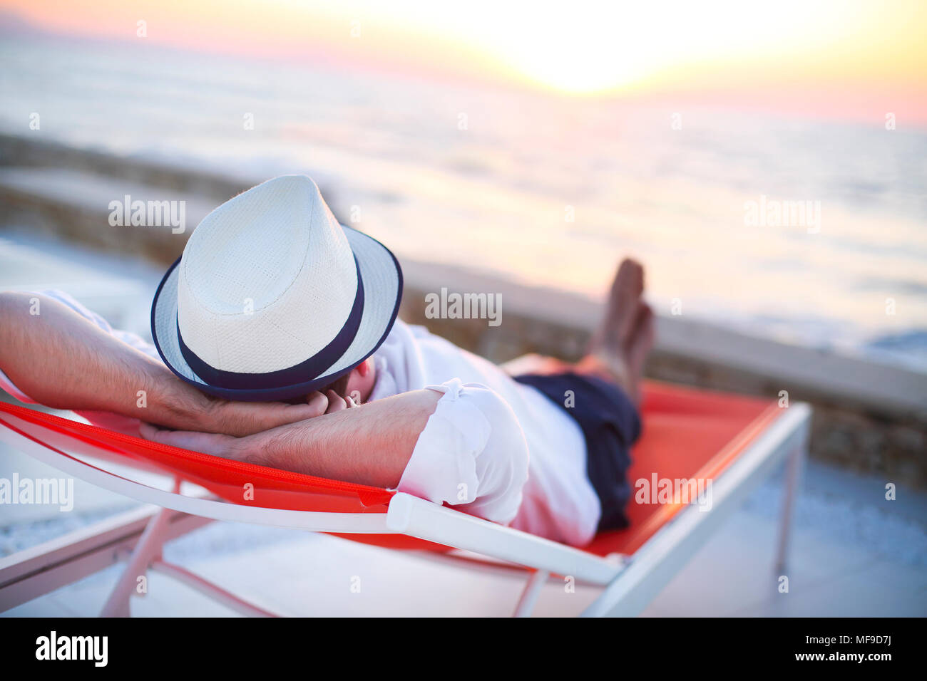 Young man relaxing on the beach back view. Summer vacation. Relax ...