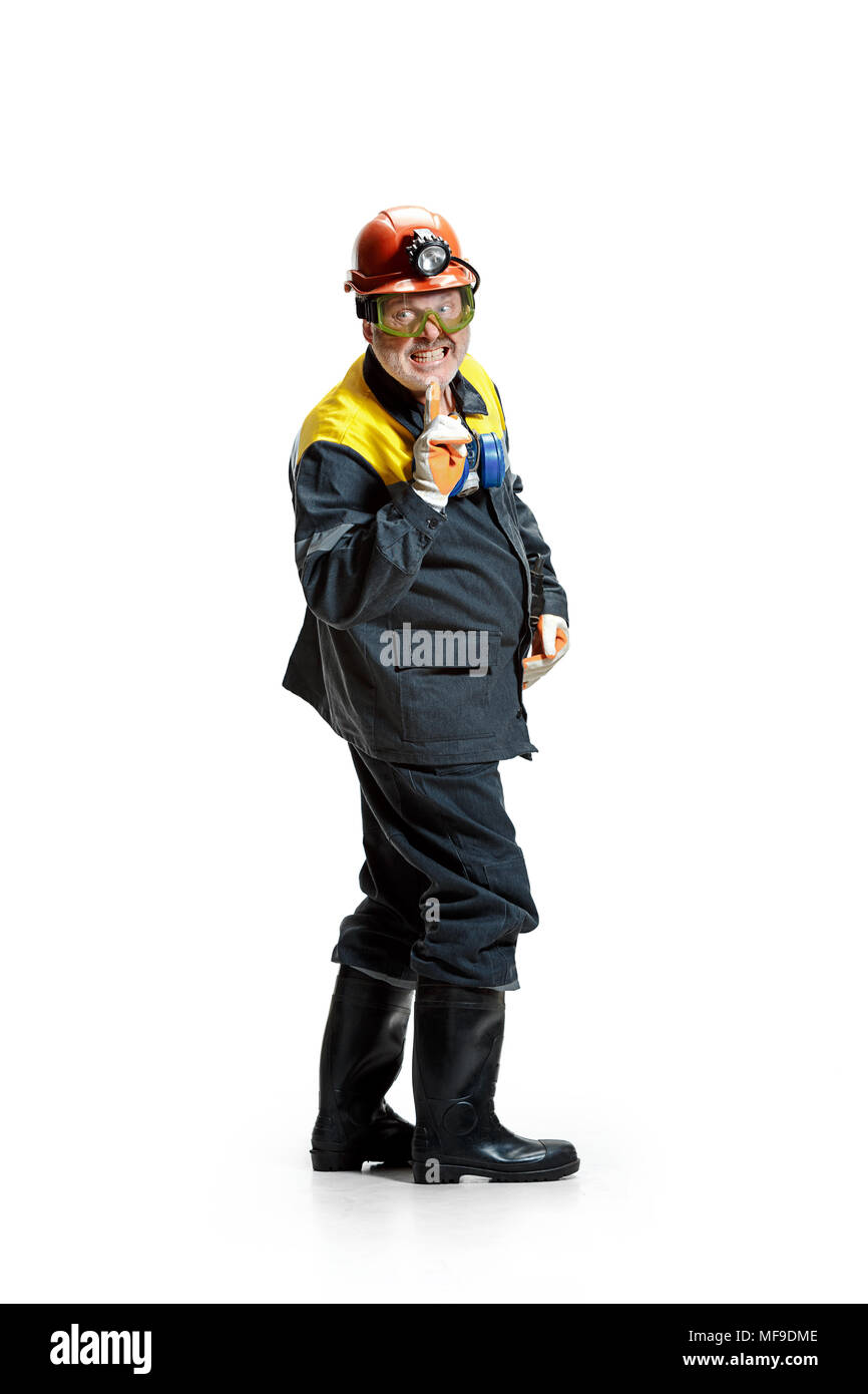 The studio shot of senior bearded male miner standing at the camera on ...