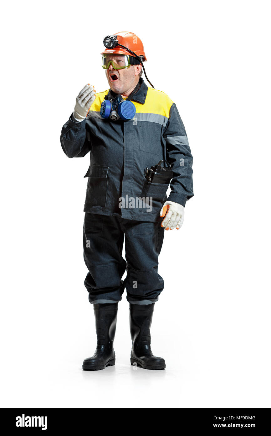 The studio shot of senior bearded male miner standing at the camera on ...