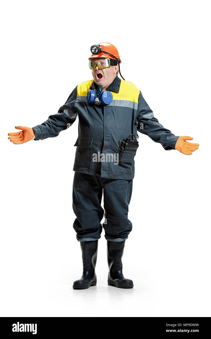 The studio shot of senior bearded male miner standing at the camera on ...