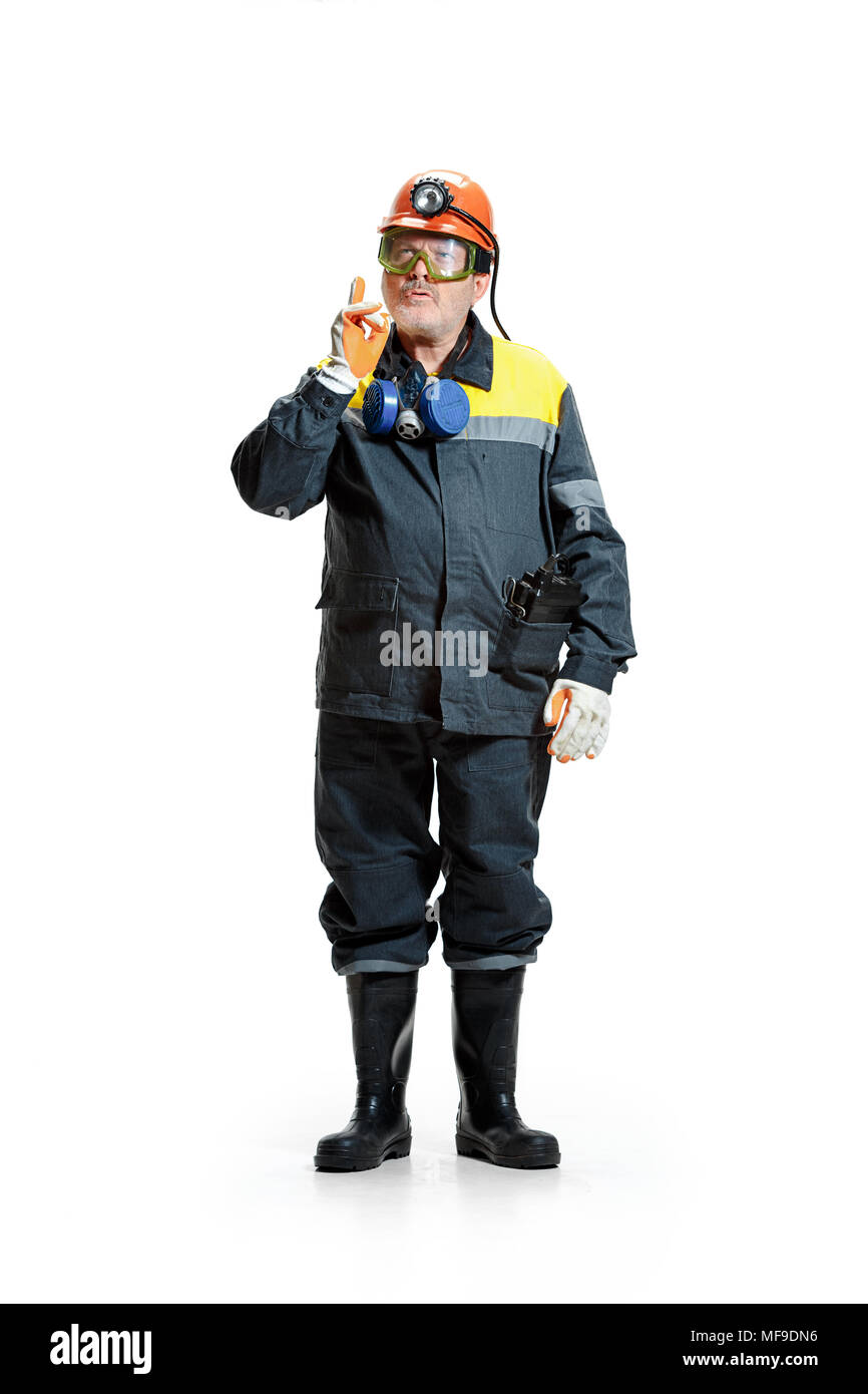 The studio shot of senior bearded male miner standing at the camera on ...