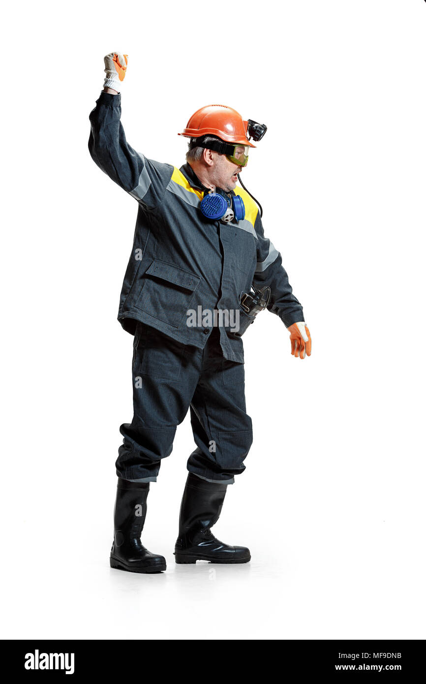 The studio shot of senior bearded male miner standing at the camera on ...