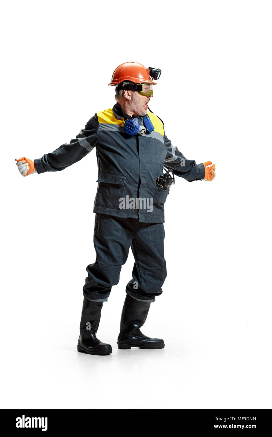 The studio shot of senior bearded male miner standing at the camera on ...