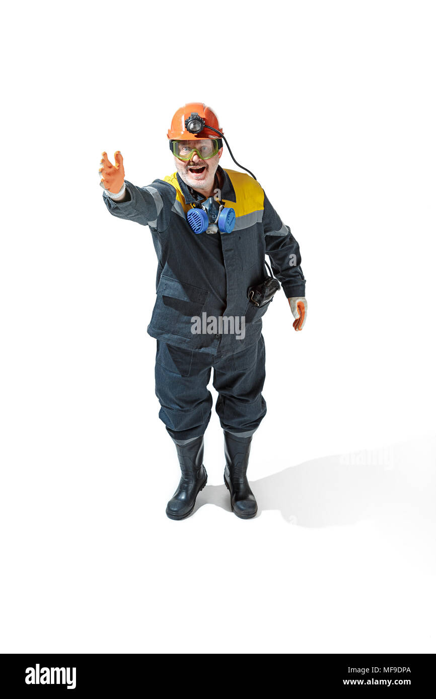 The studio shot of senior bearded male miner standing at the camera on ...