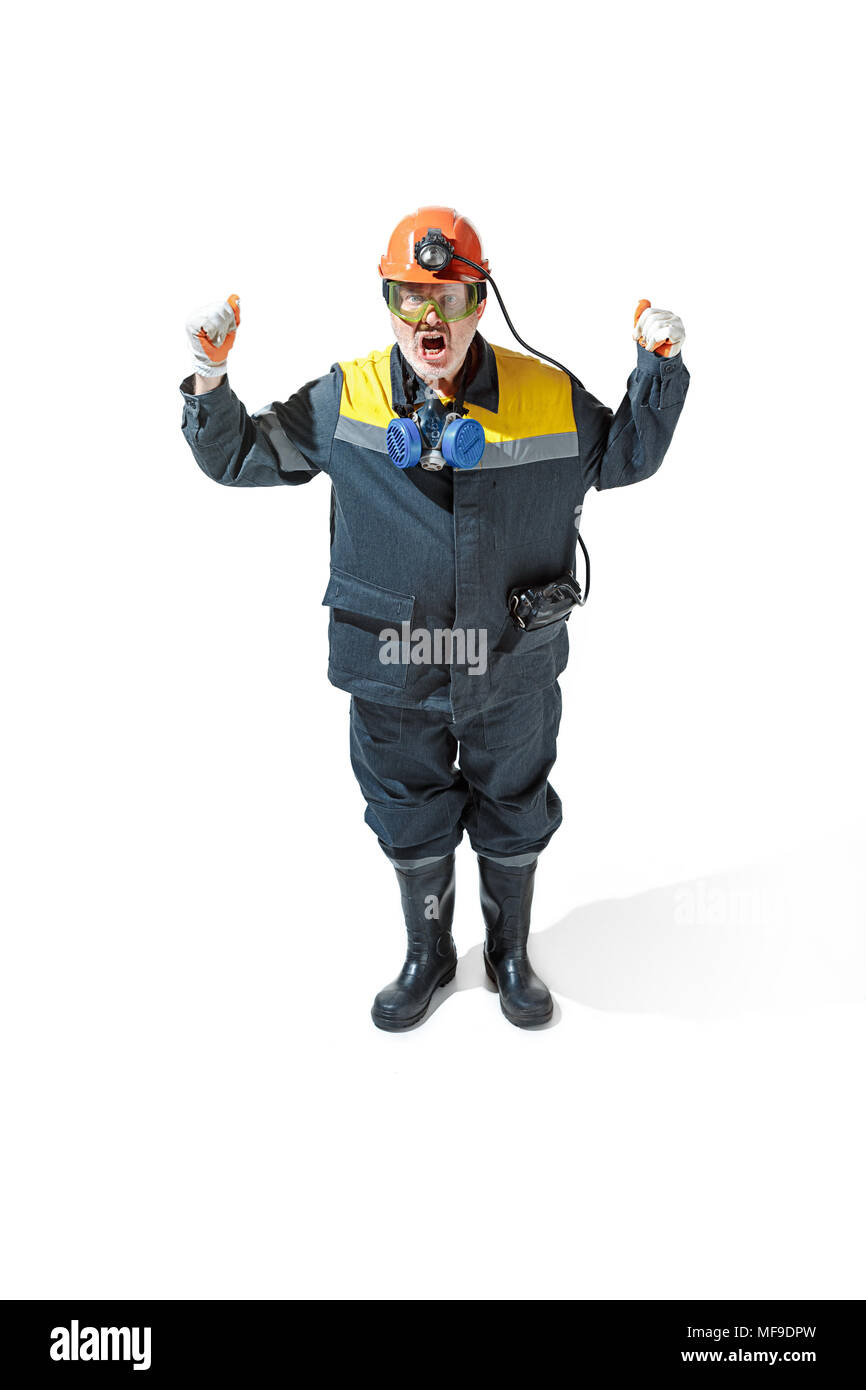 The studio shot of senior bearded male miner standing at the camera on ...