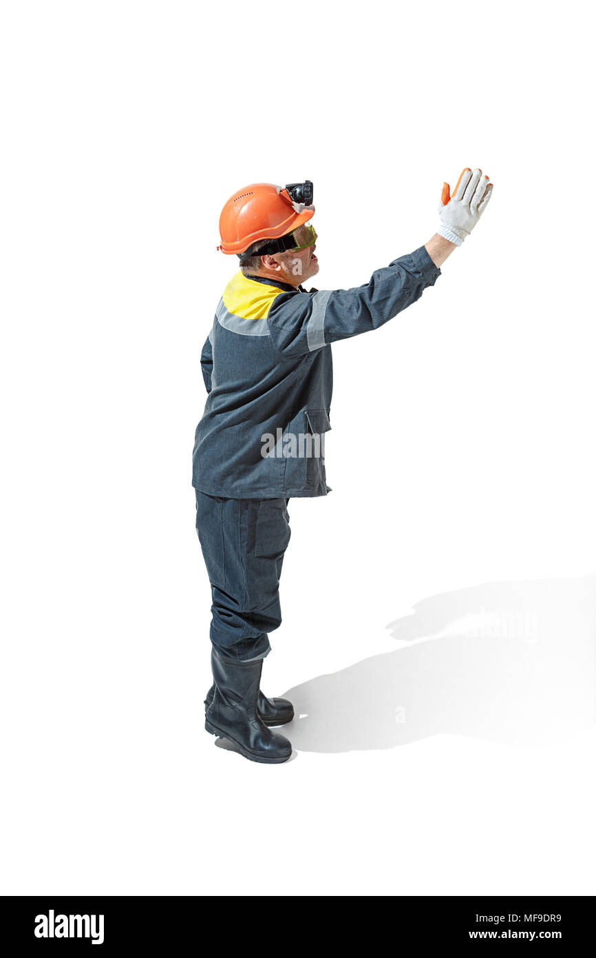 The studio shot of senior bearded male miner standing at the camera on ...