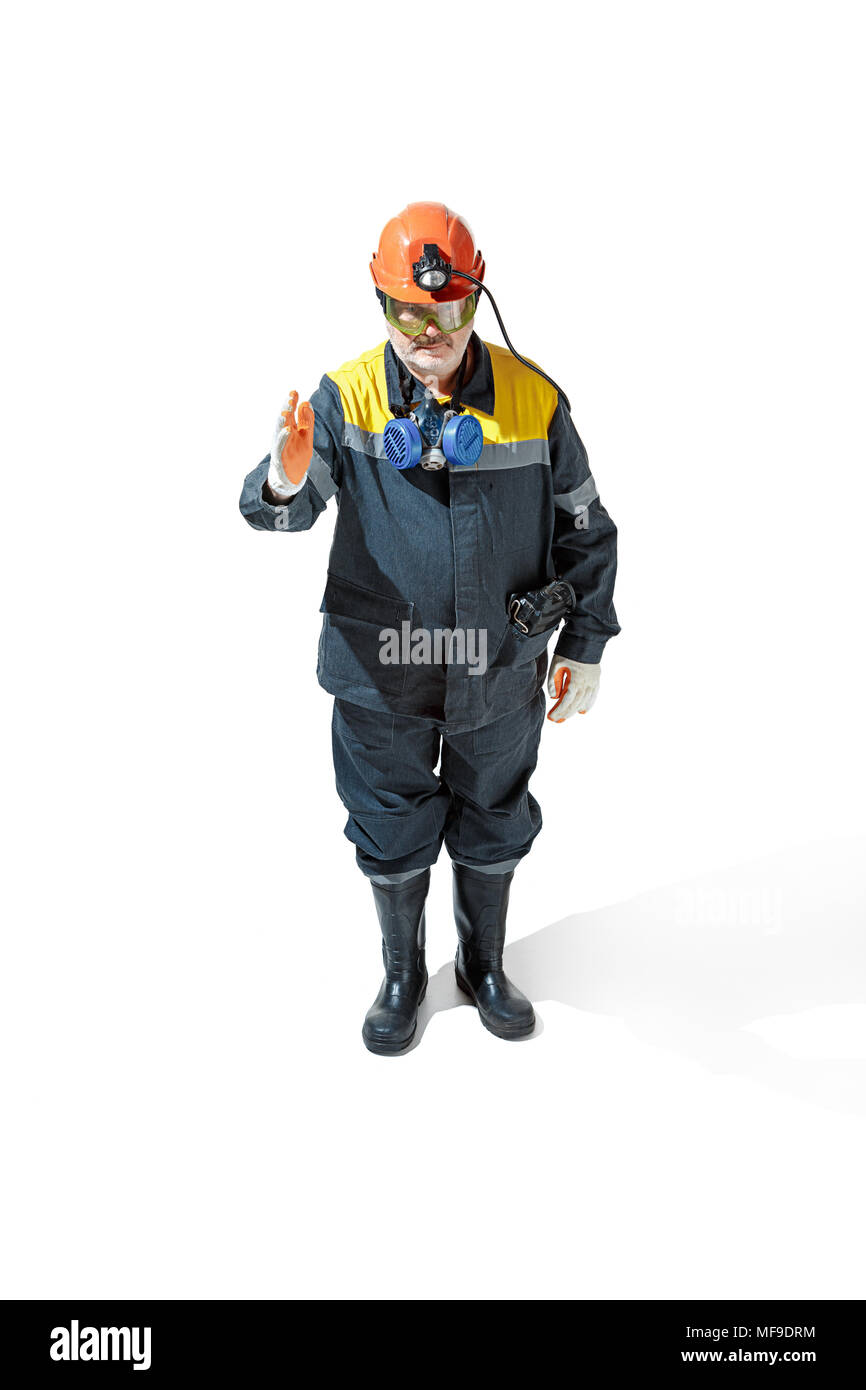 The studio shot of senior bearded male miner standing at the camera on ...