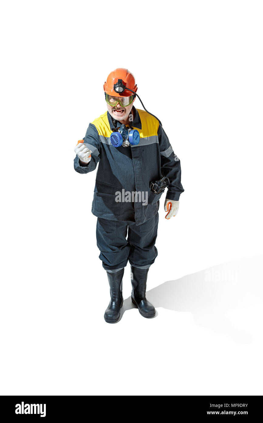The studio shot of senior bearded male miner standing at the camera on ...