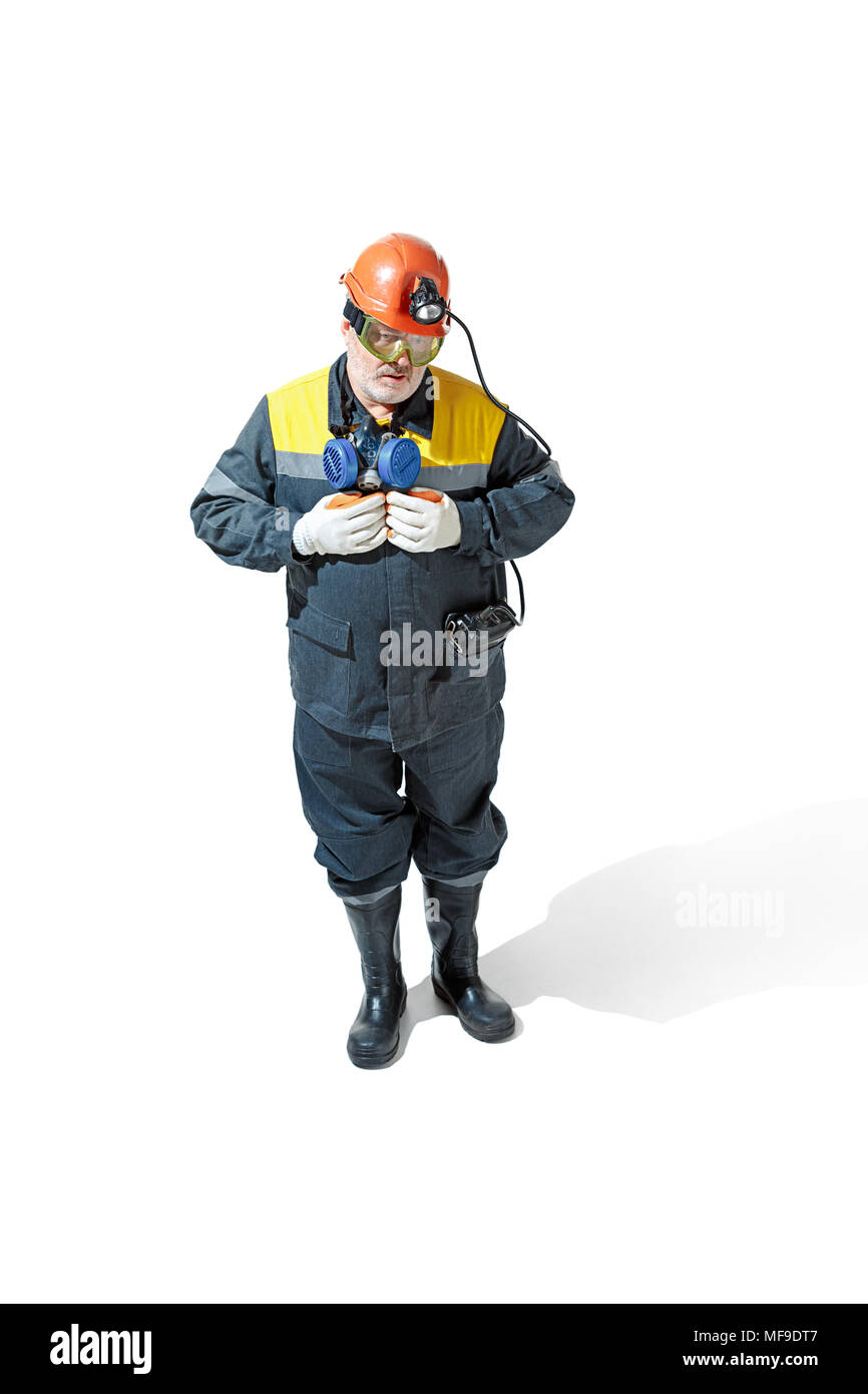 The studio shot of senior bearded male miner standing at the camera on ...
