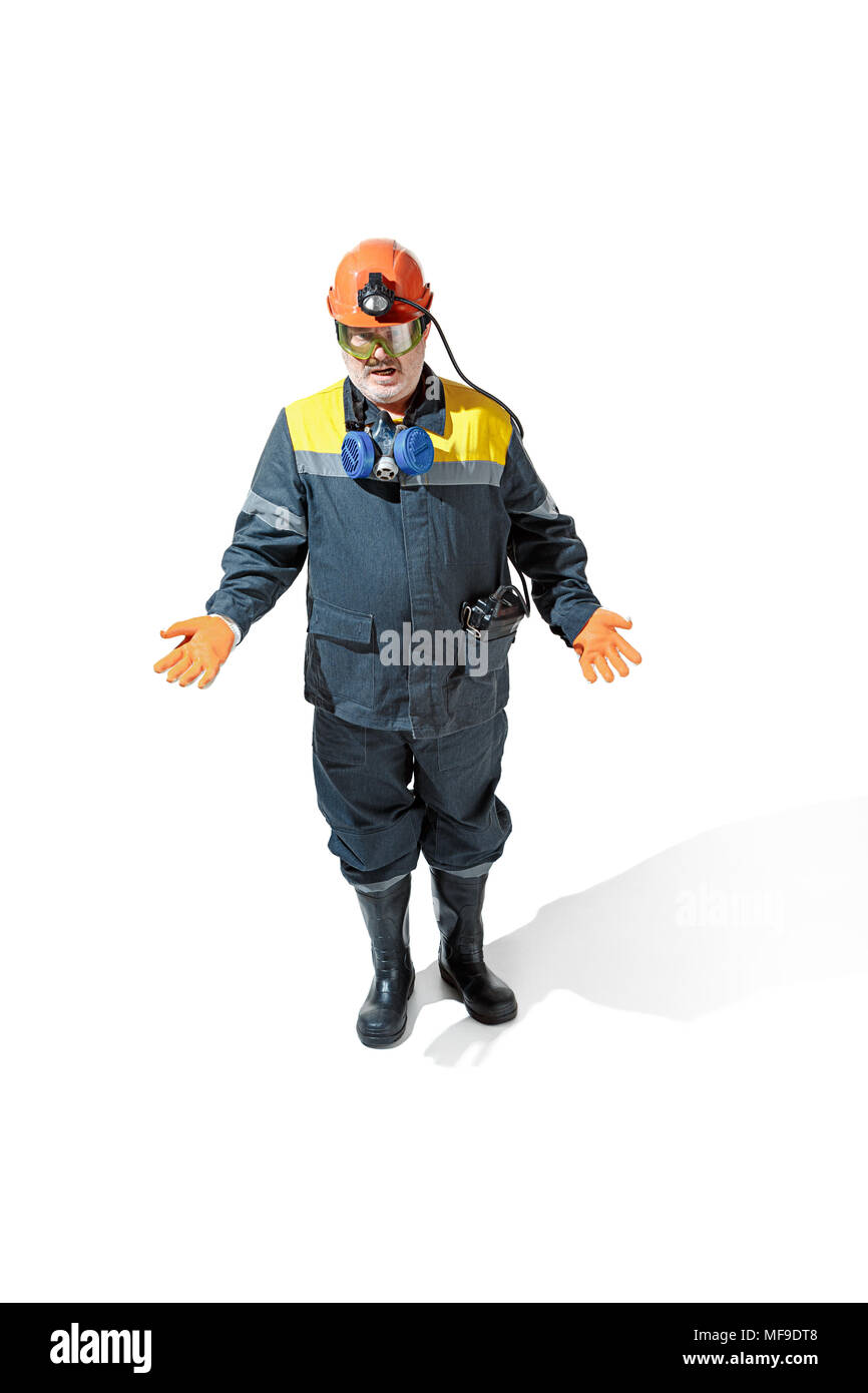 The studio shot of senior bearded male miner standing at the camera on ...