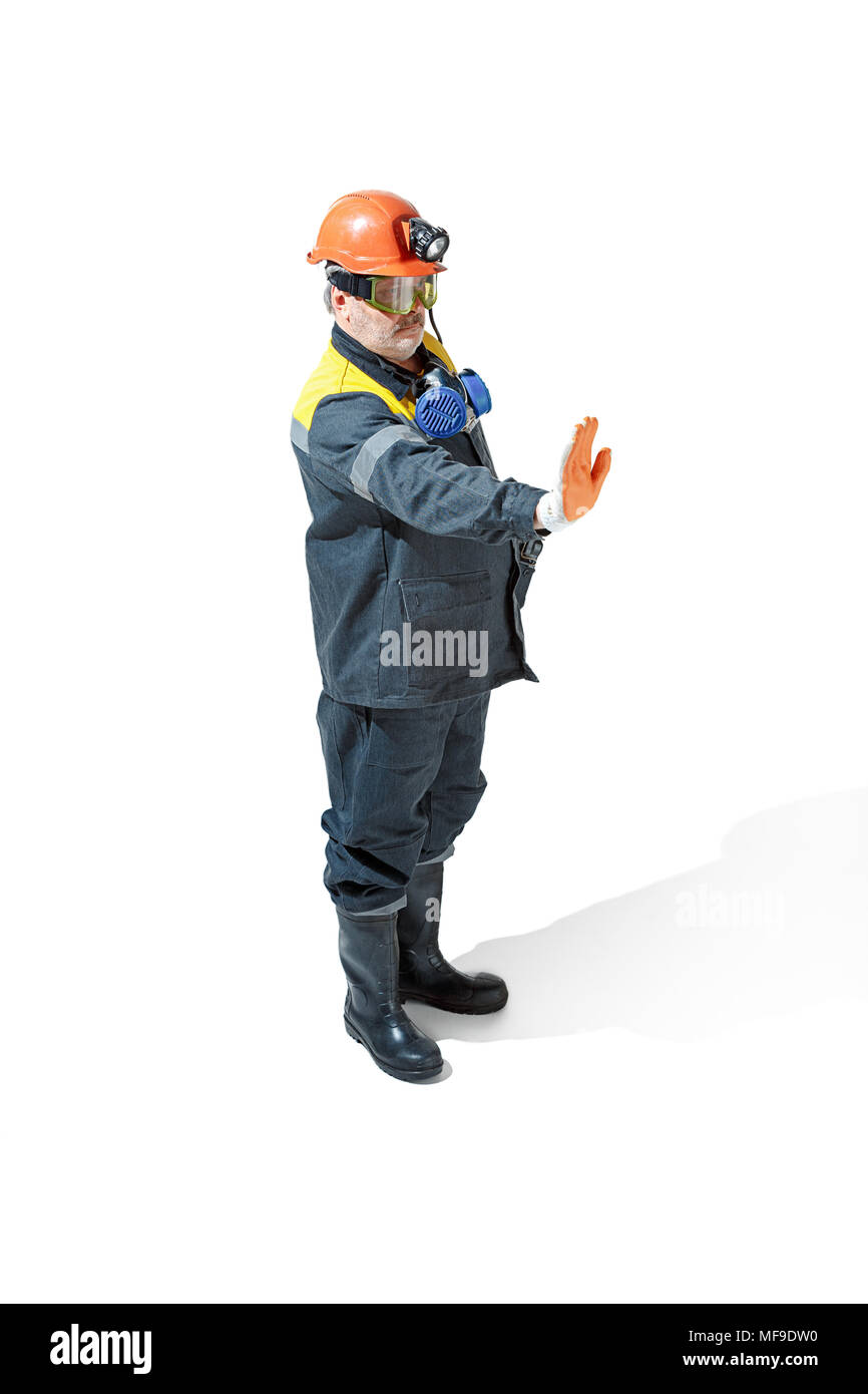 The studio shot of senior bearded male miner standing at the camera on ...