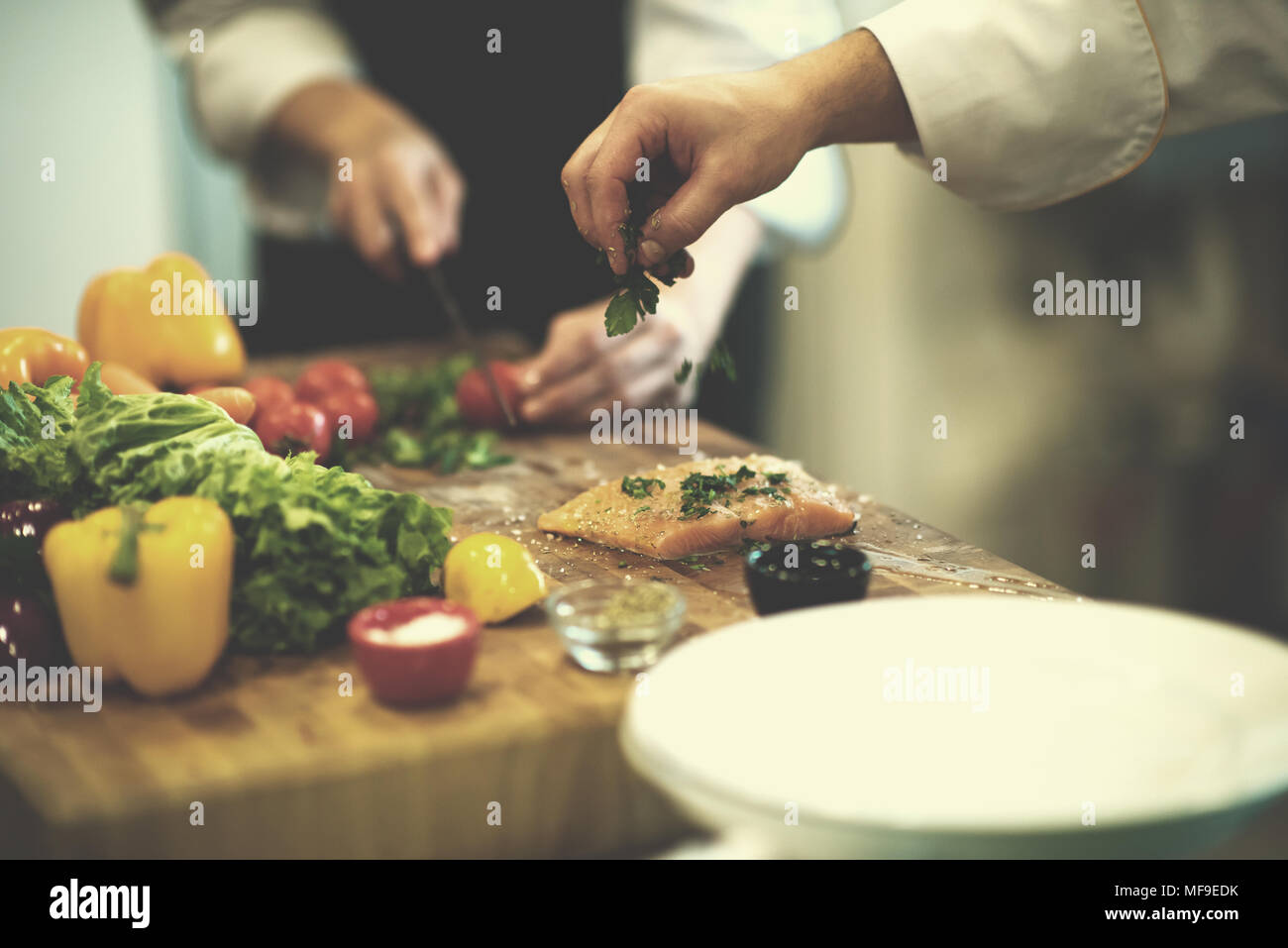 Chef hands preparing marinated Salmon fish fillet for frying in a ...
