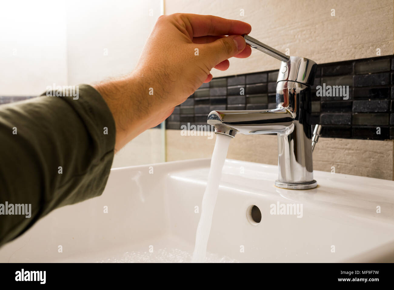 man's hand opens the tap Stock Photo - Alamy