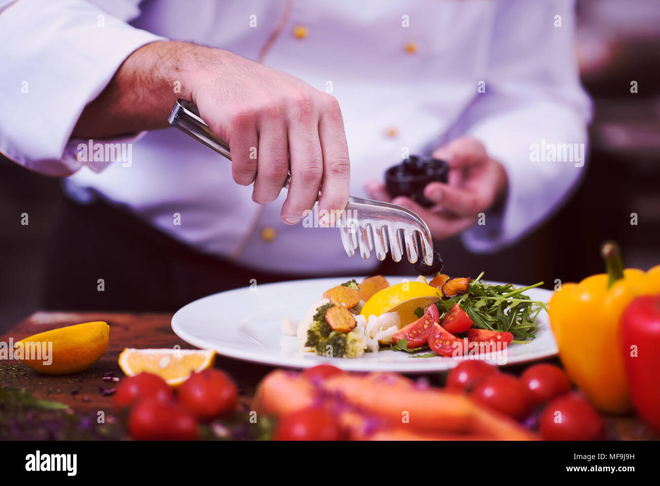 chef serving vegetable salad on plate in restaurant kitchen Stock Photo ...