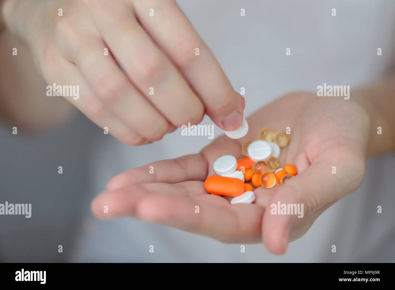 the woman counts the tablets in the palm of your hand. Many pills in ...