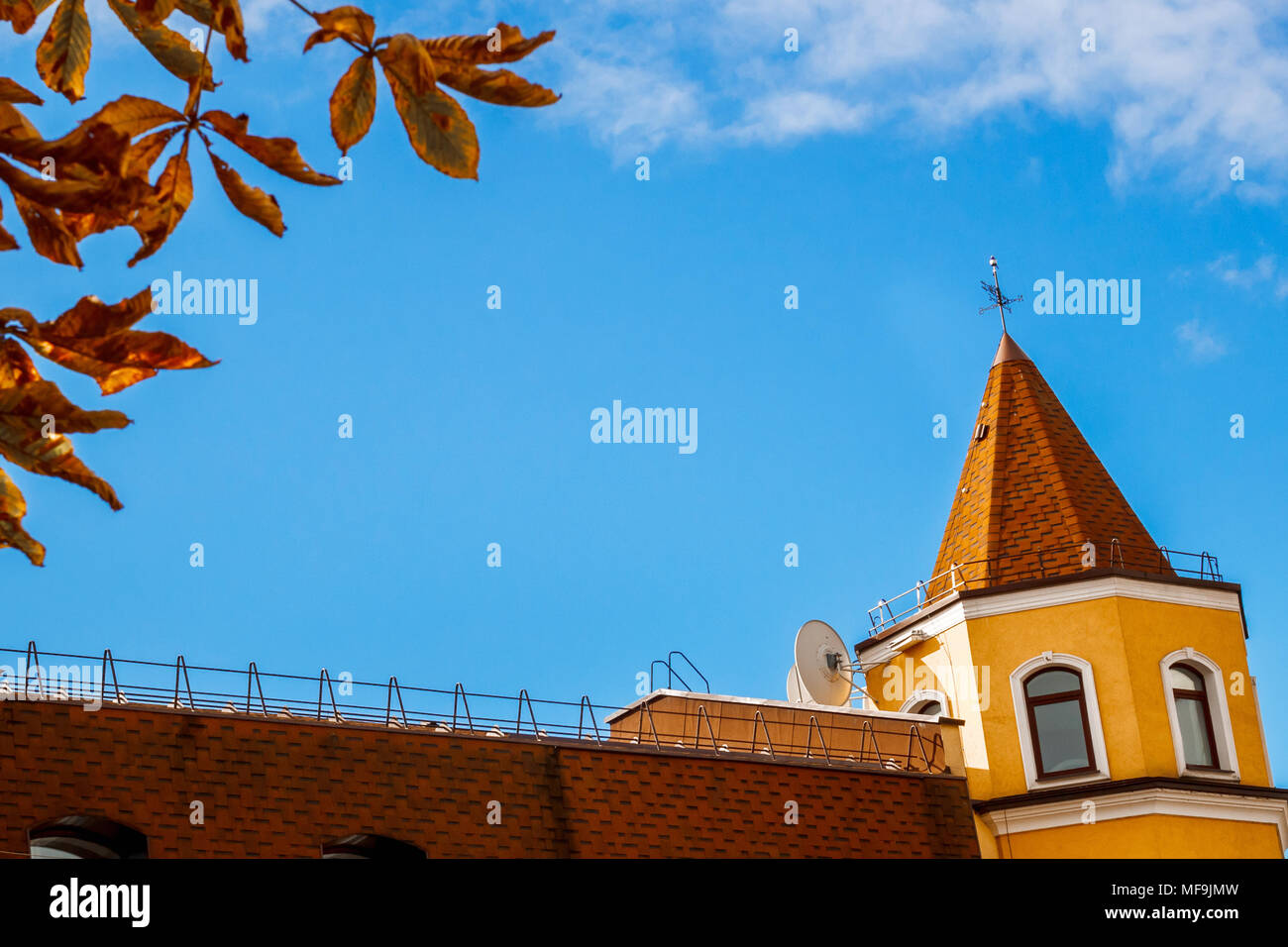building with a spire on a blue sky background. Finial on top of peaked ...