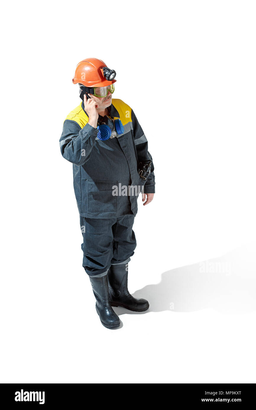 The studio shot of senior bearded male miner standing at the camera on ...