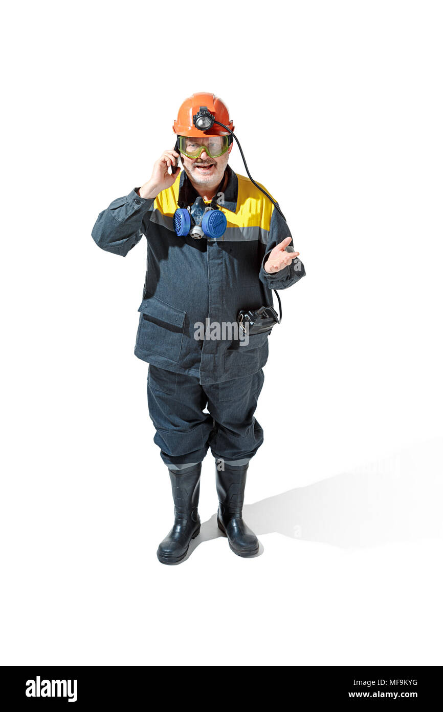 The studio shot of senior bearded male miner standing at the camera on ...