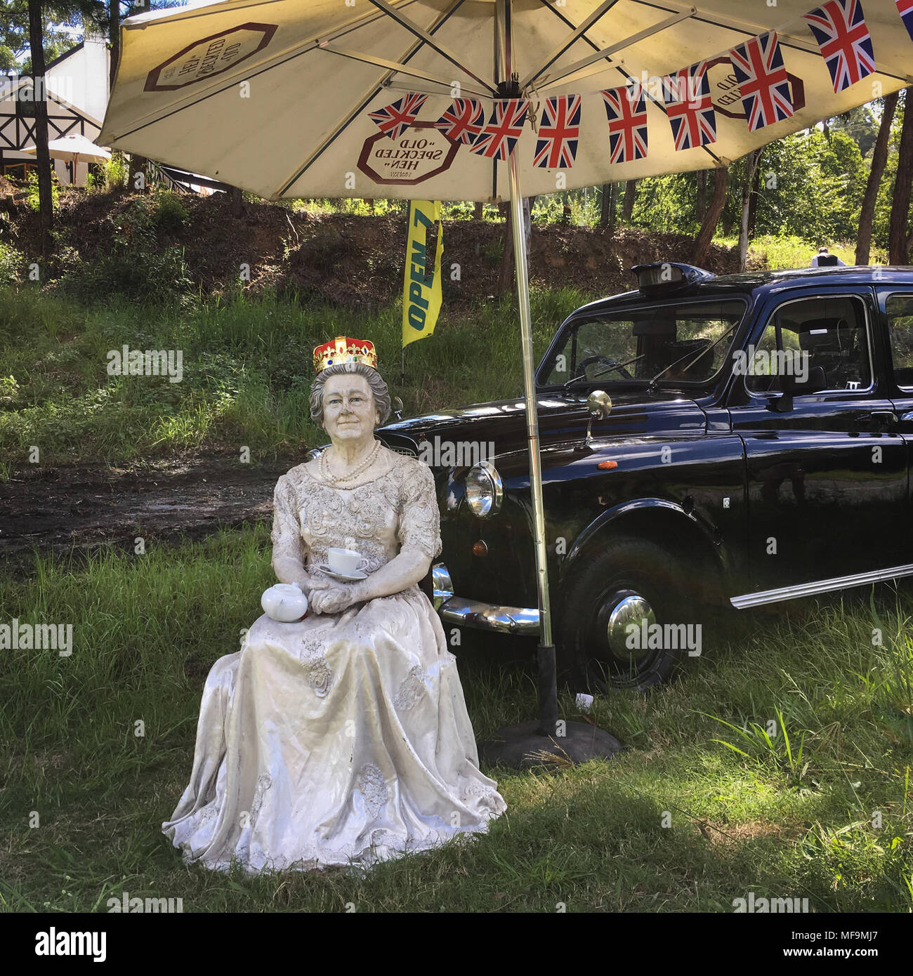 A model of Queen Elizabeth II, and a back London taxi, outside a pub in ...