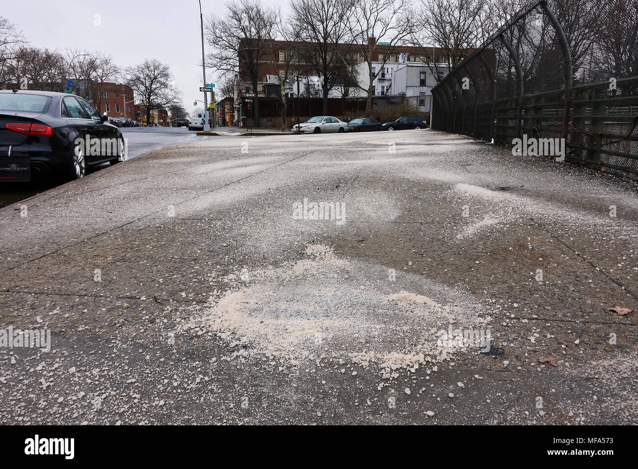 salt on the walk side of the street in advance of a snow storm in NYC ...