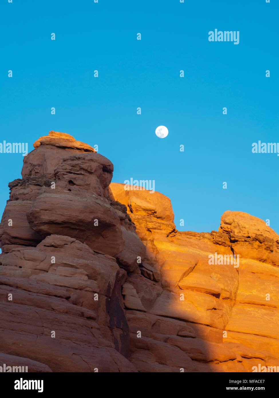 The moon rises over sandstone at dusk. Arches National Park, Moab, Utah ...