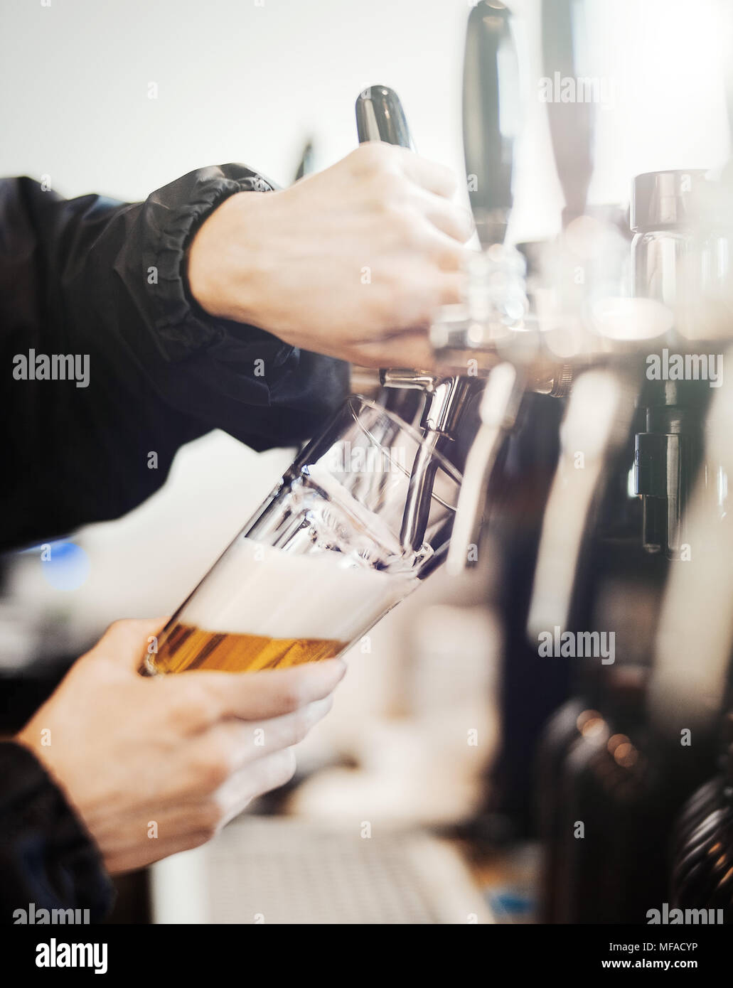 Bartender man poors glass of beer Stock Photo - Alamy
