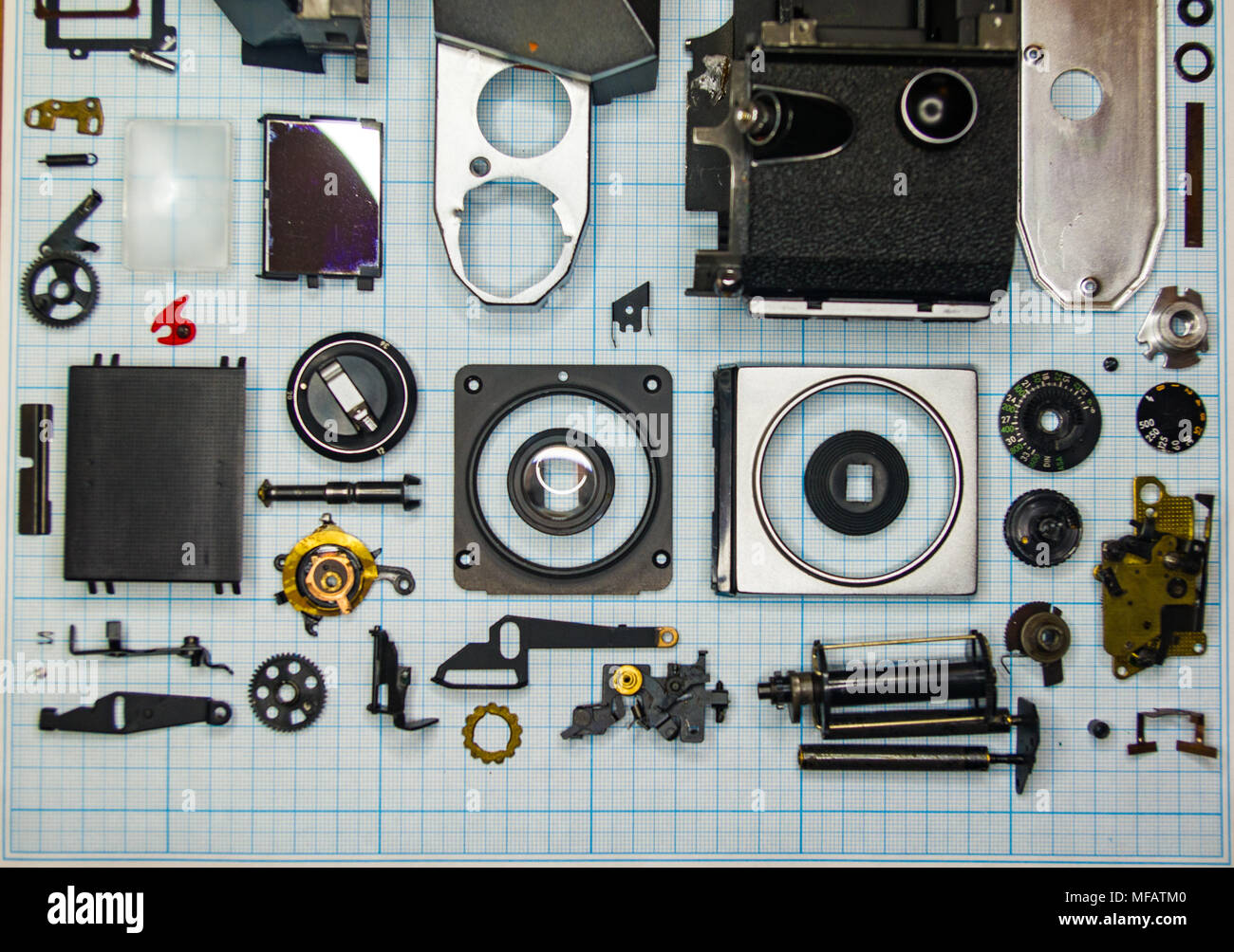 parts are completely disassembled old retro film SLR camera on graph ...