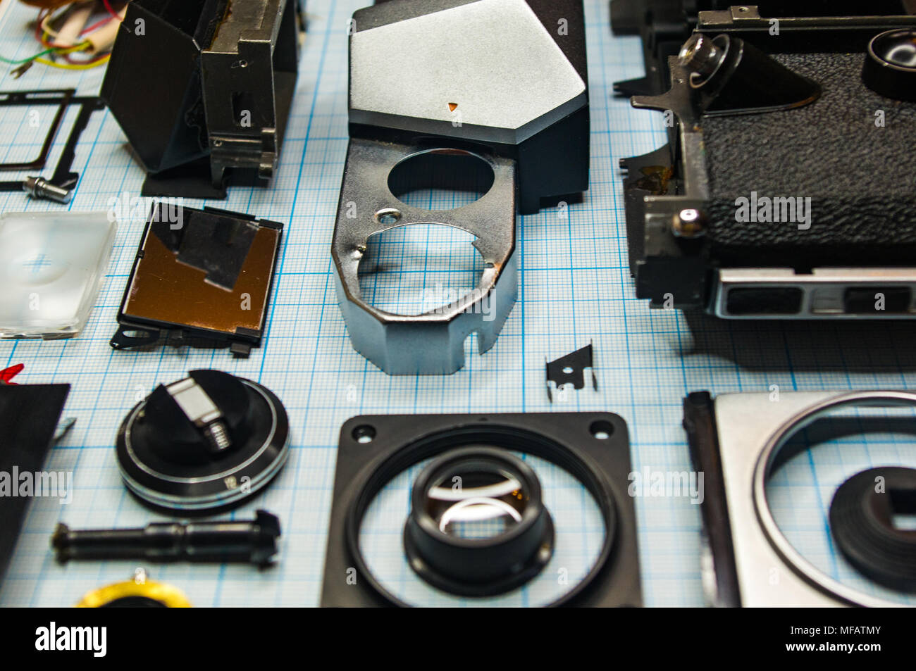 parts are completely disassembled old retro film SLR camera on graph ...