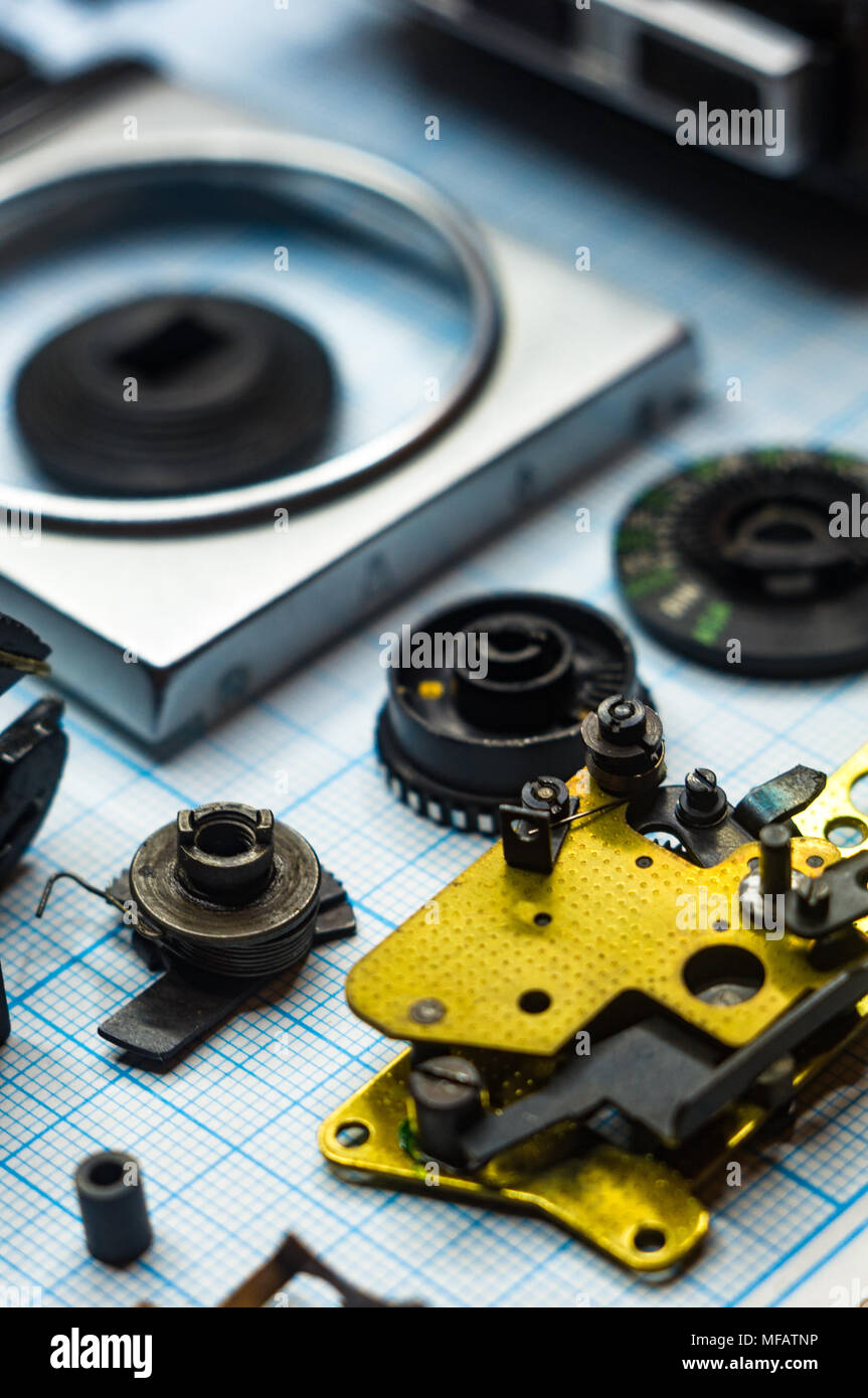 parts are completely disassembled old retro film SLR camera on graph ...