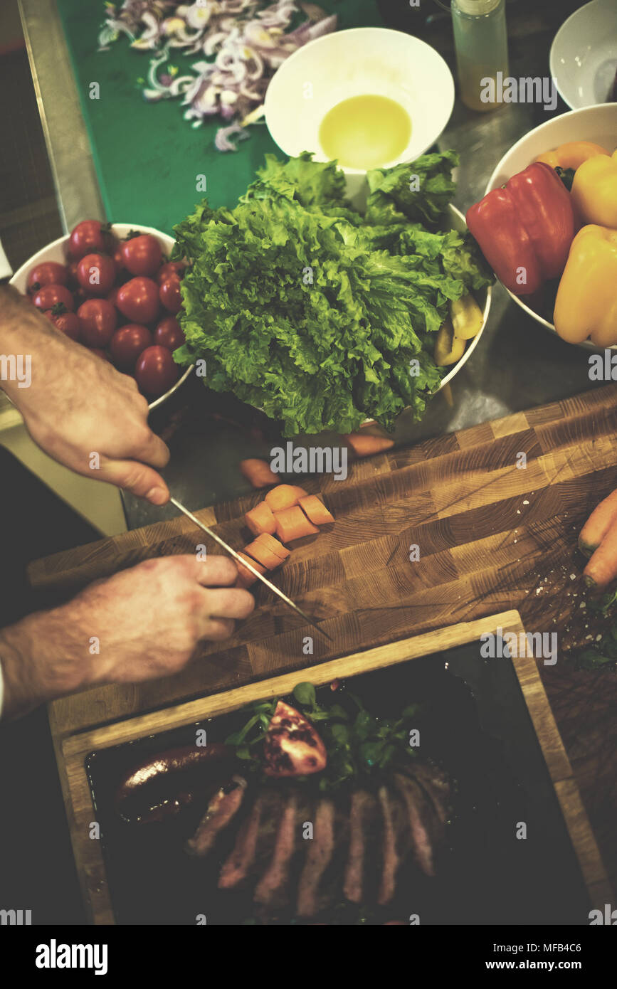 top view of Chef hands in hotel or restaurant kitchen serving beef ...