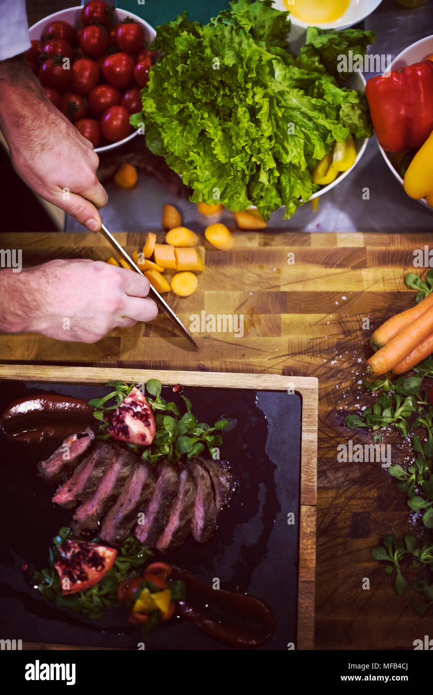 top view of Chef hands in hotel or restaurant kitchen serving beef ...
