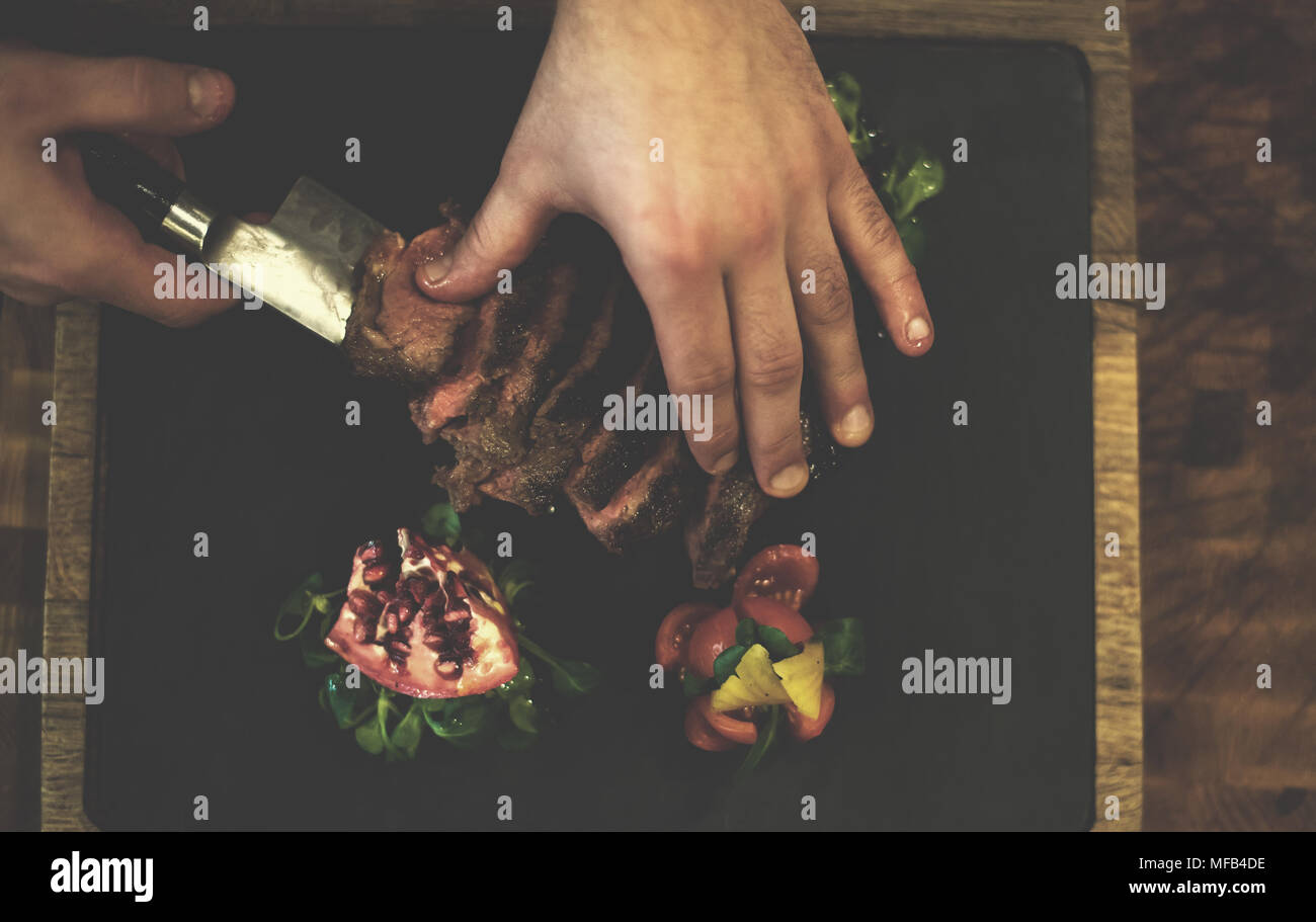 top view of Chef hands in hotel or restaurant kitchen serving beef ...