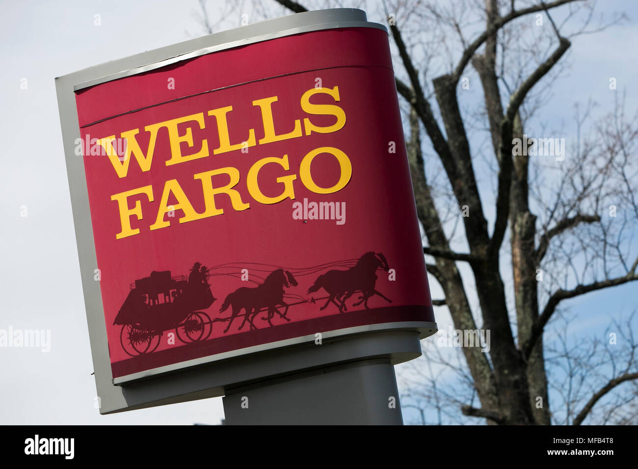 A logo sign outside of a Wells Fargo bank branch in North Wales ...