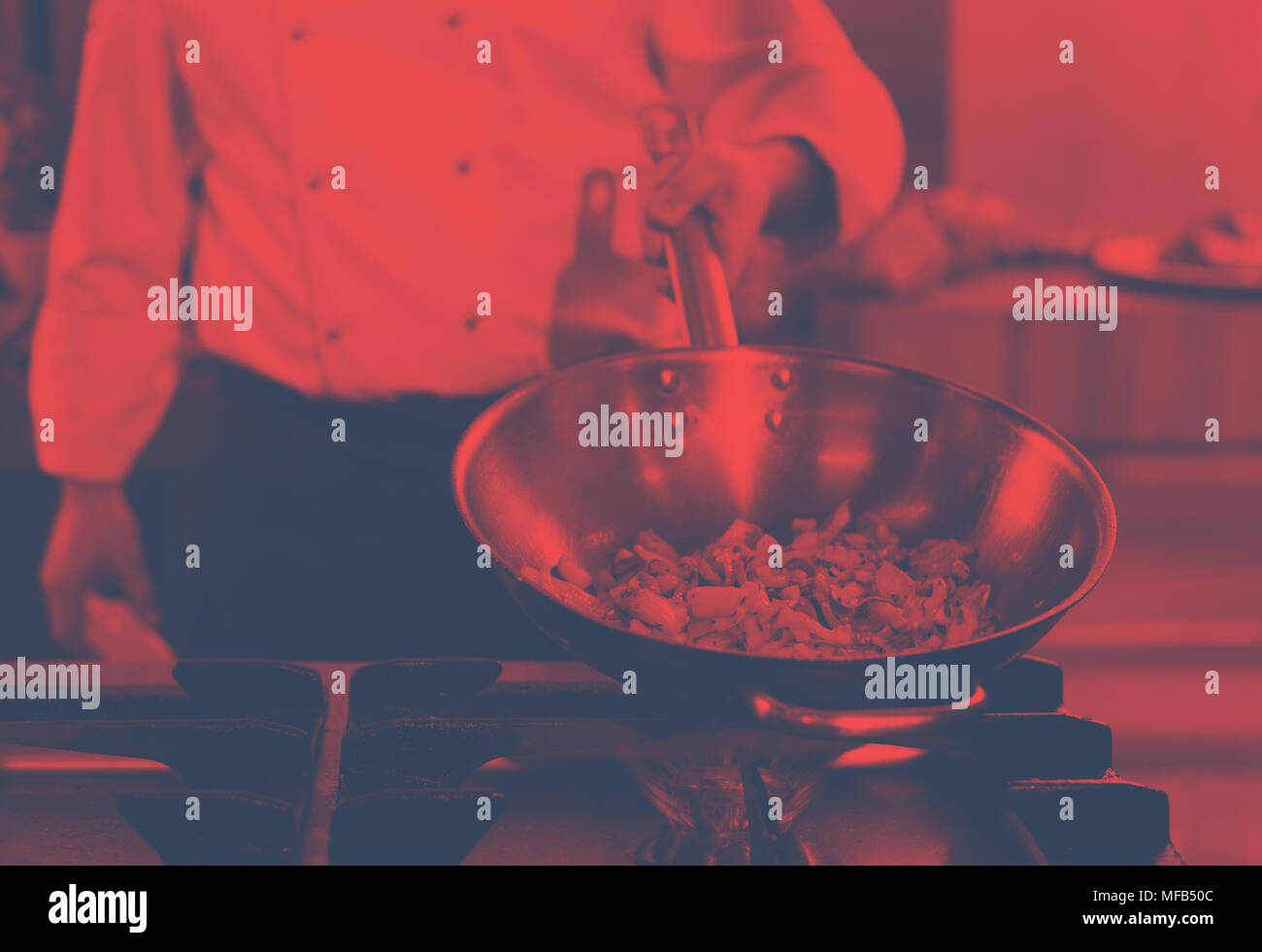 Young male chef flipping vegetables in wok at commercial kitchen Stock ...