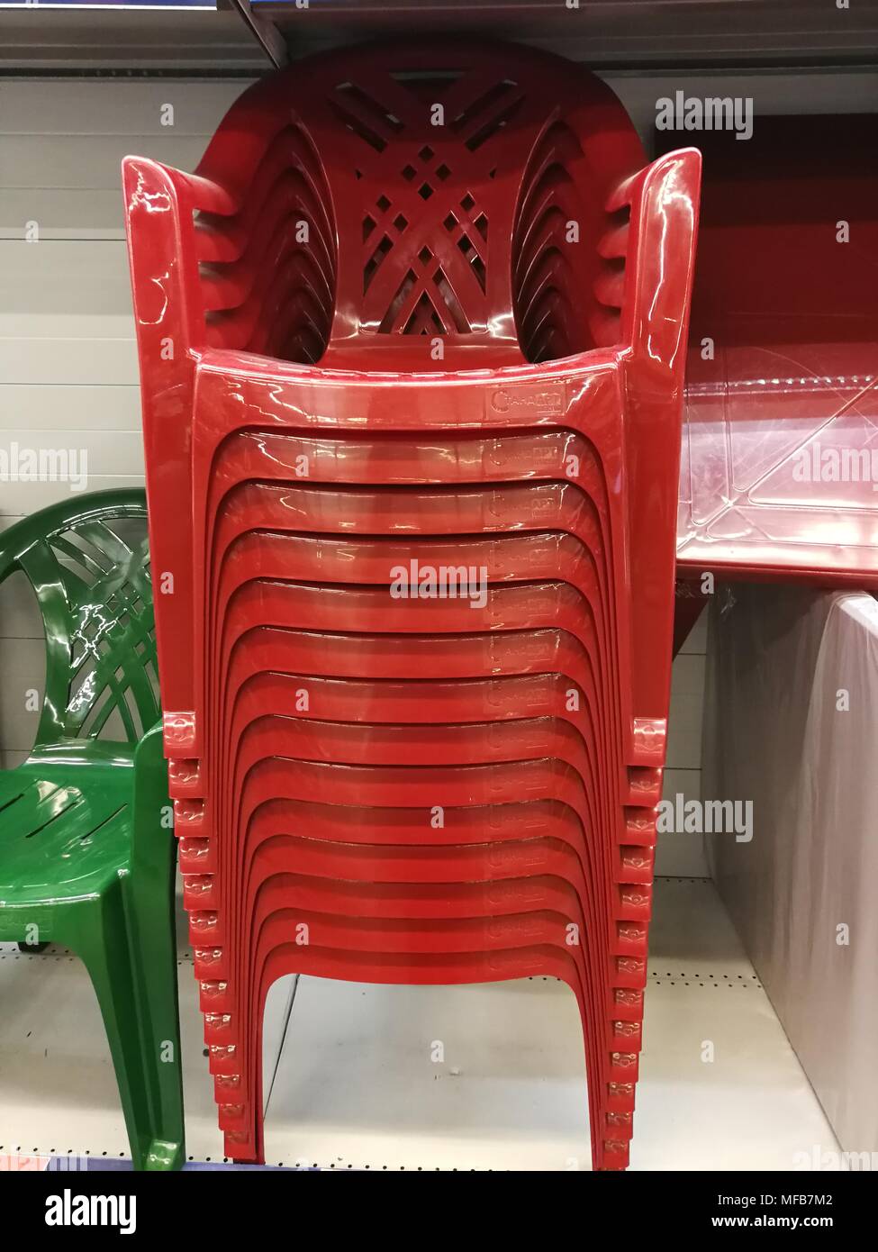 Stacked in rows of red plastic chairs on the storefront Stock Photo - Alamy