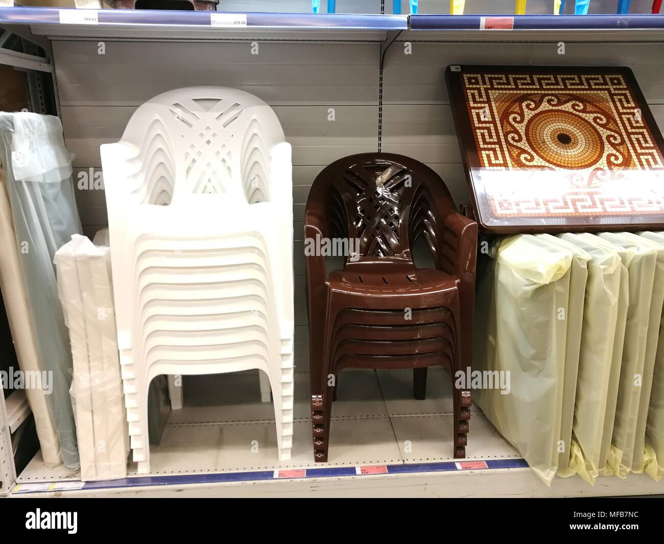 Stacked in rows of plastic chairs are ready for sale in the store Stock ...