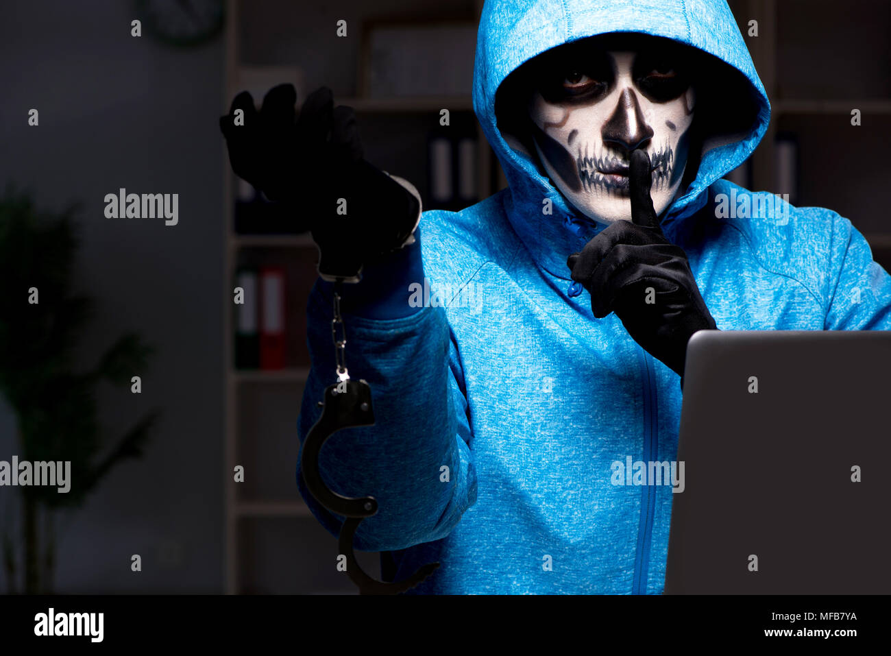 Scary hacker hacking security firewall late in office Stock Photo - Alamy