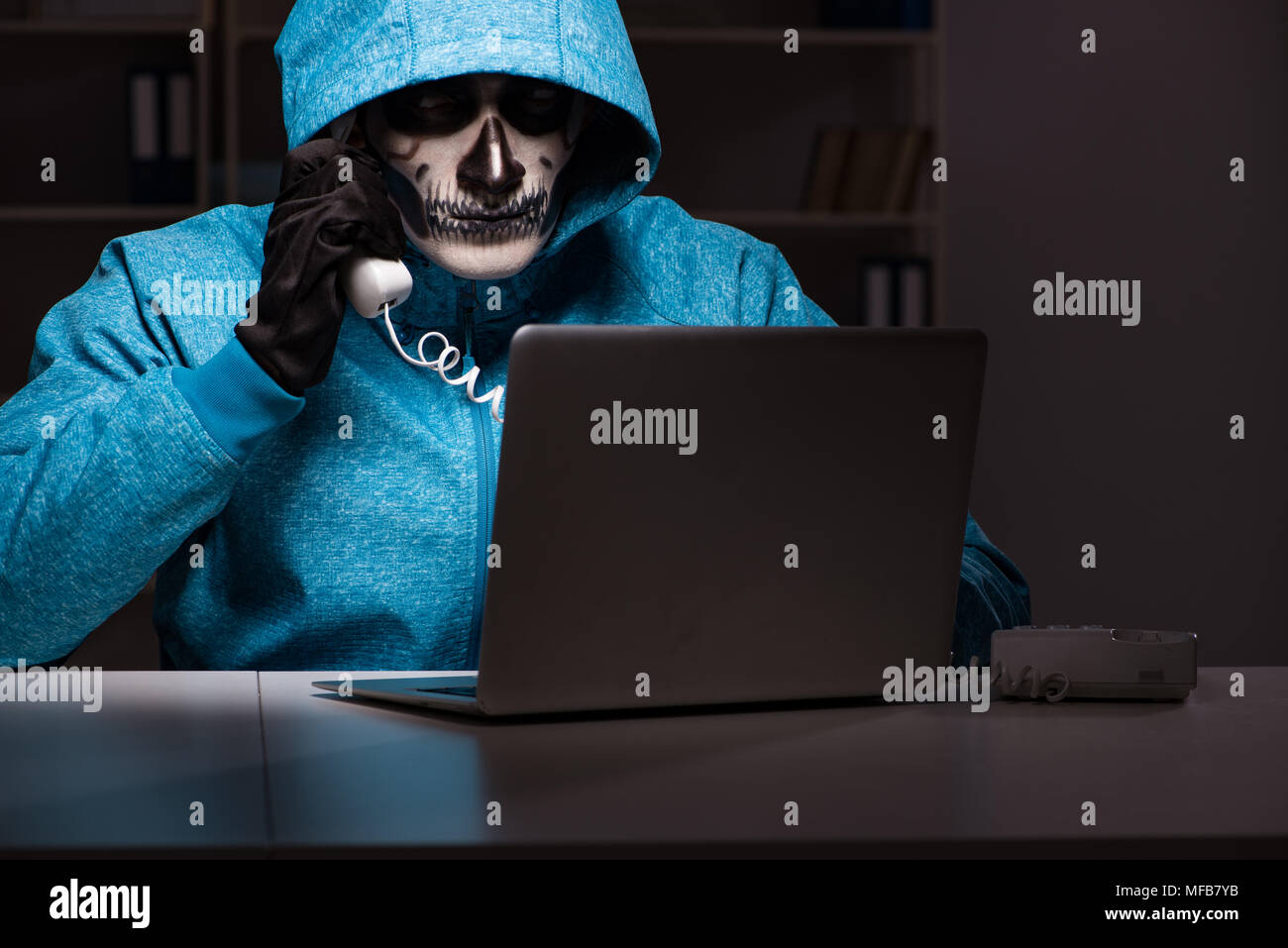 Scary hacker hacking security firewall late in office Stock Photo - Alamy